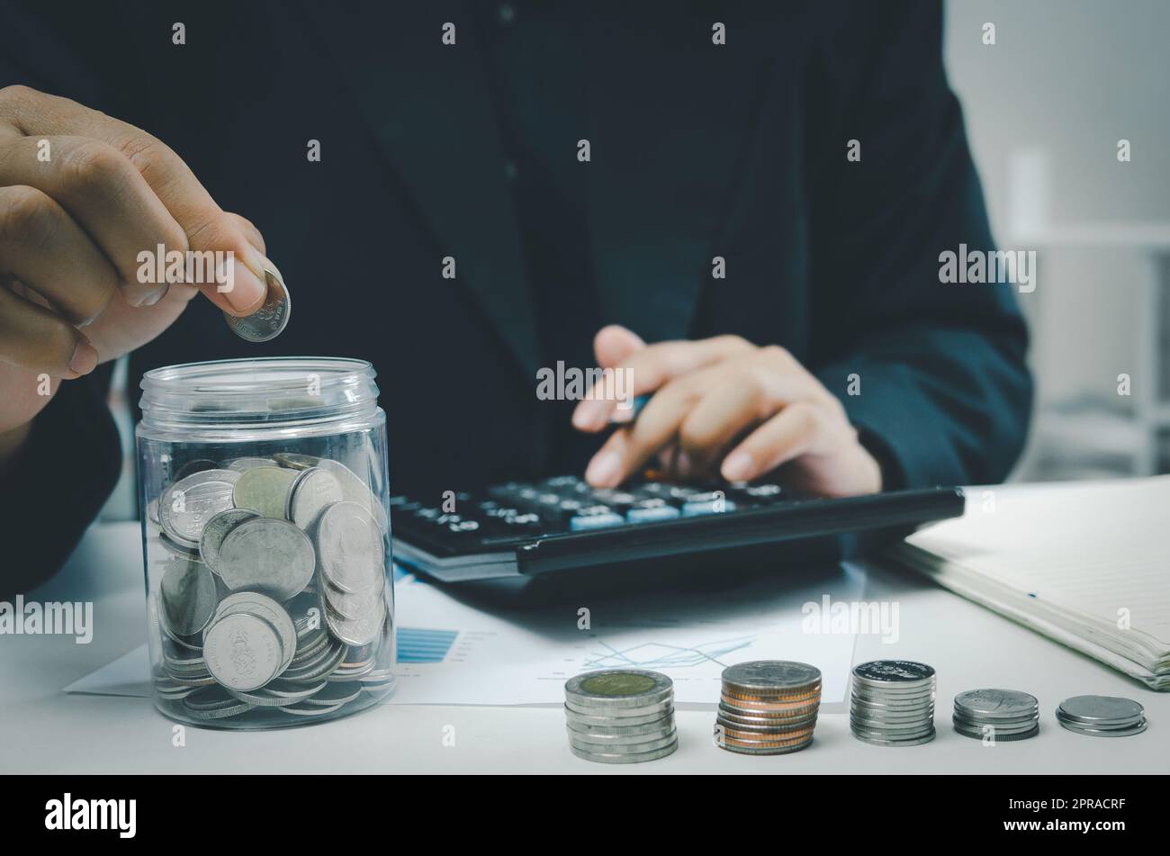 Hand holding money coin saving investment in jar.Business finance ...