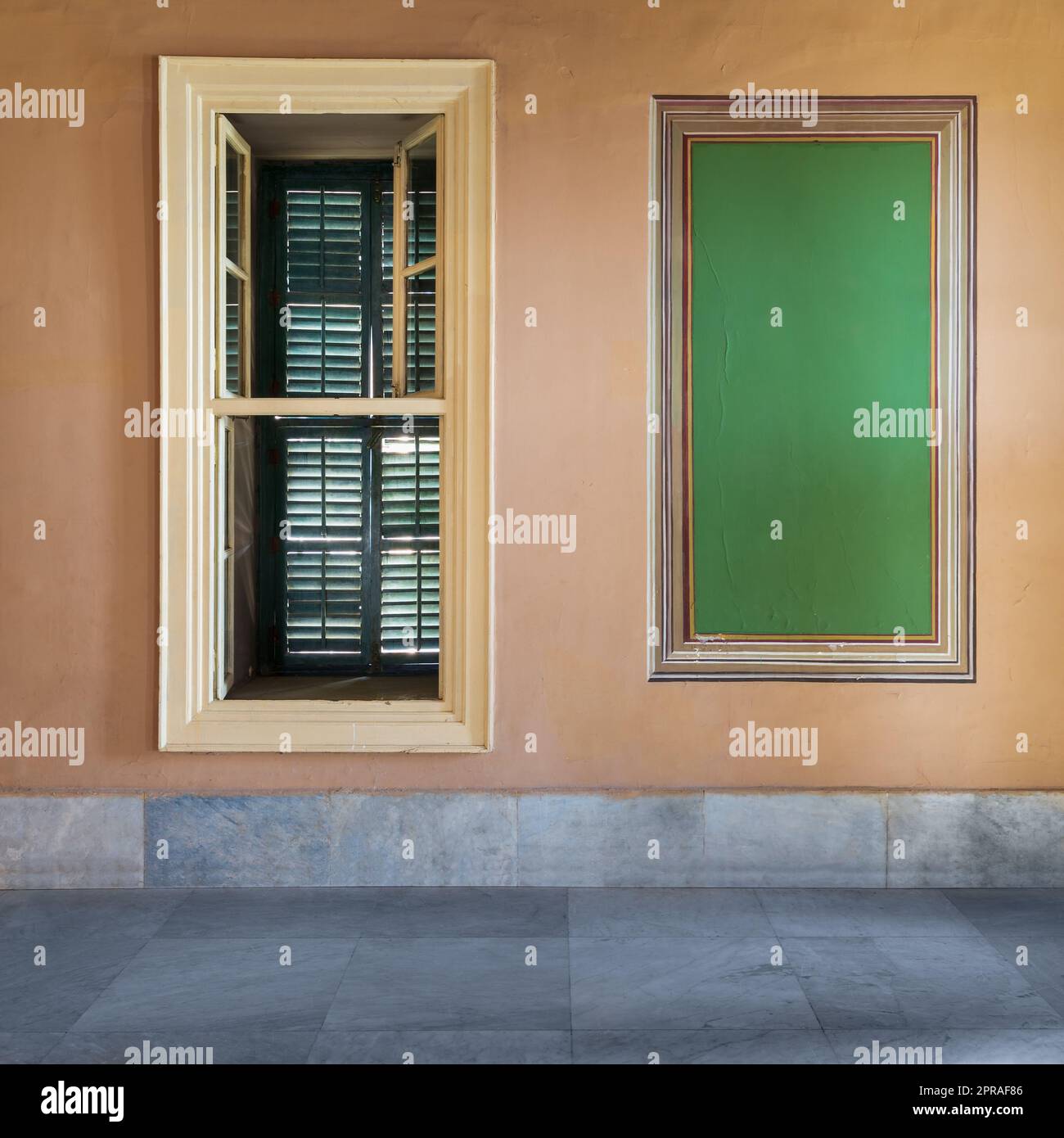 Green frame with ornate border and window with closed green shutter on ...