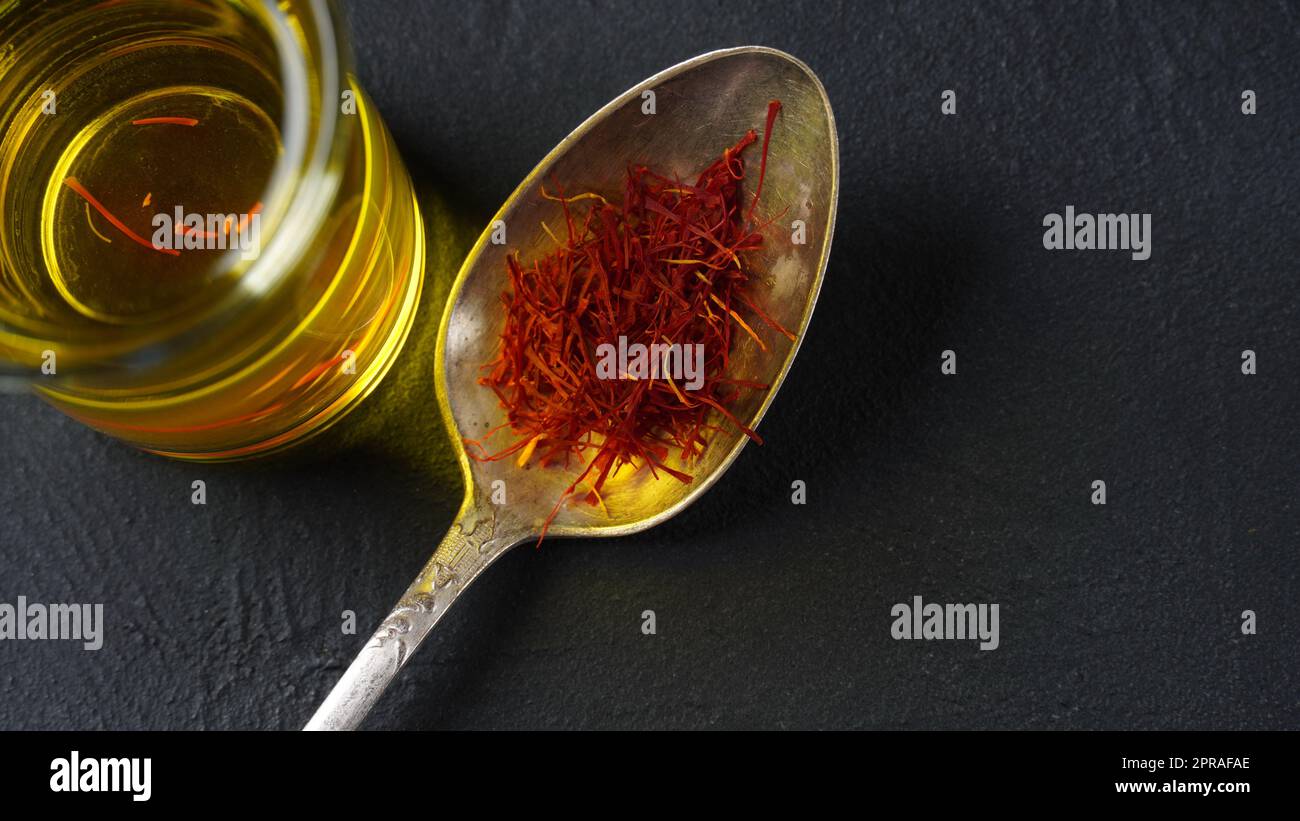 Expensive Red Dried saffron spice in a spoon on dark background Stock ...