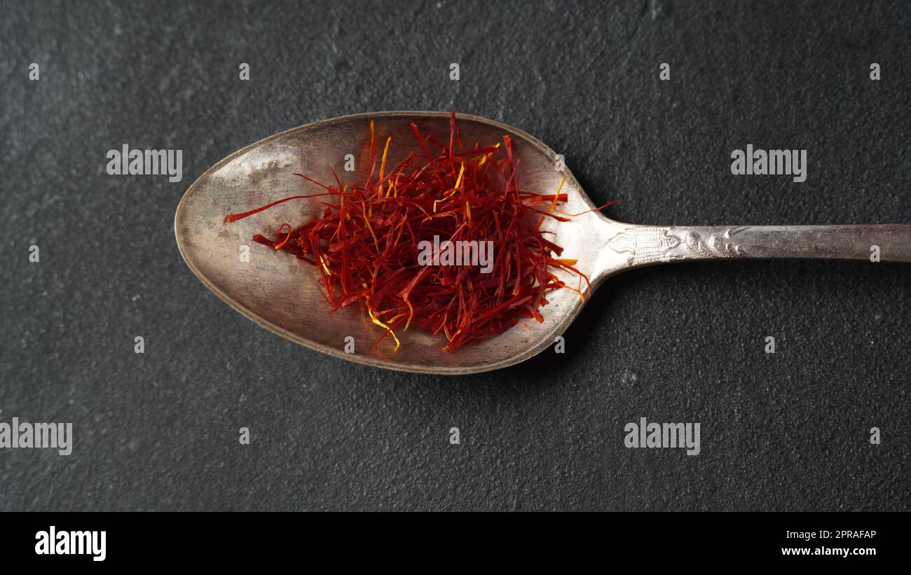 Expensive Red Dried saffron spice in a spoon on dark background Stock ...