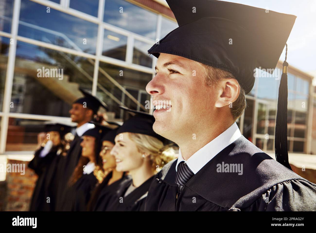 Looking ahead to his future. students standing outside on graduation ...
