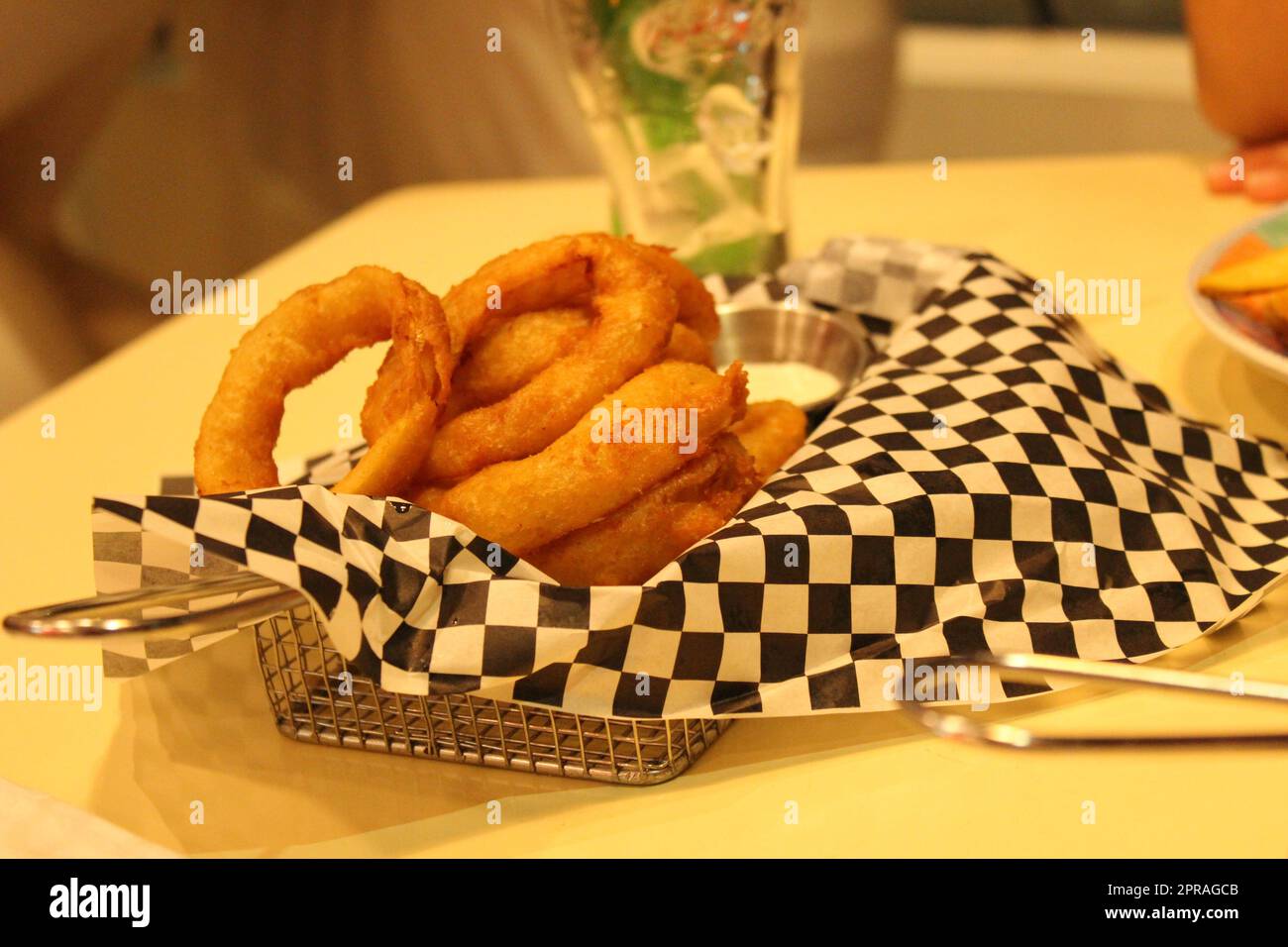 A basket of golden-brown onion rings at a restaurant Stock Photo - Alamy