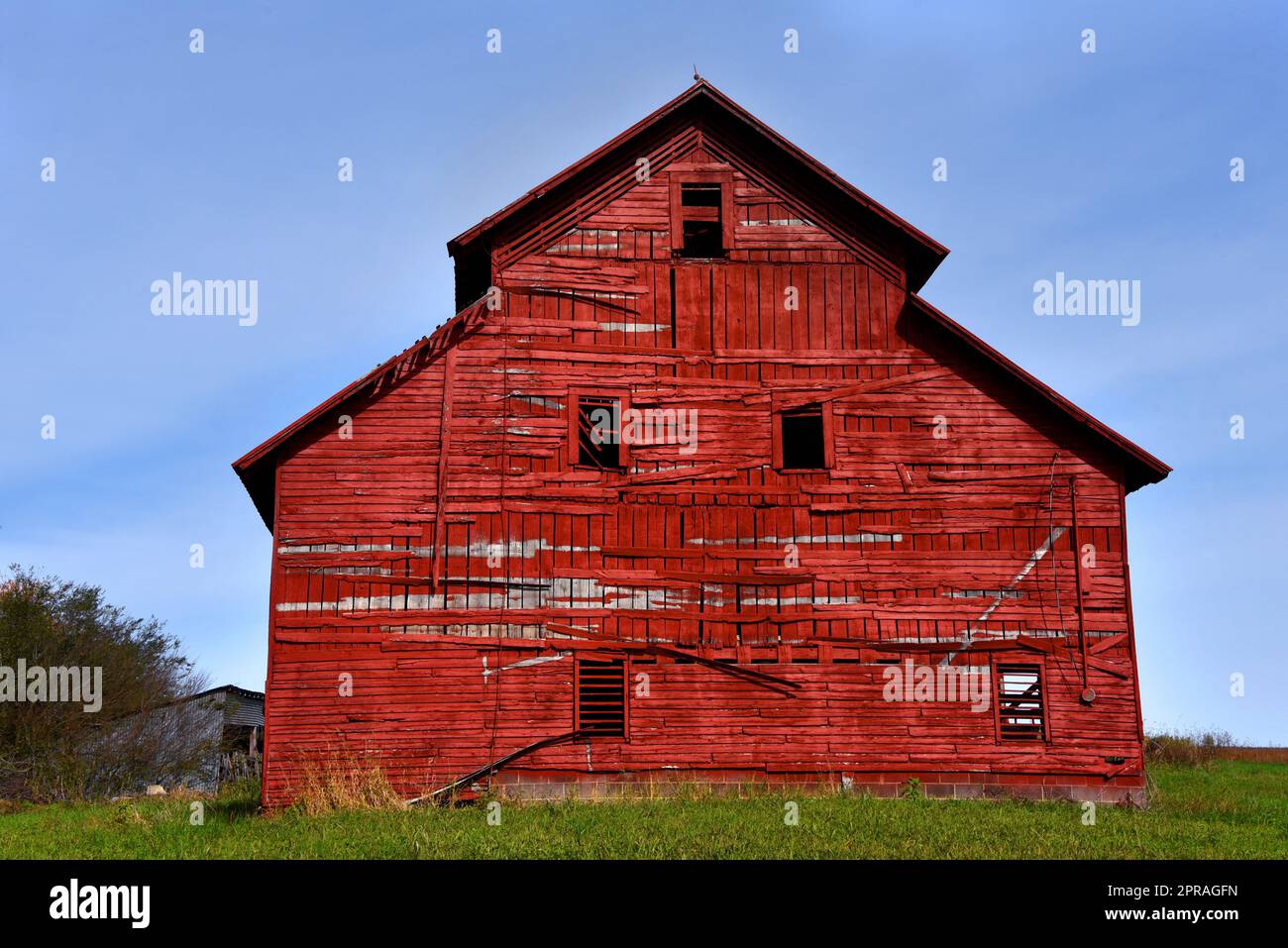 Red, red, wooden barn has three stories. Boards are falling off ...