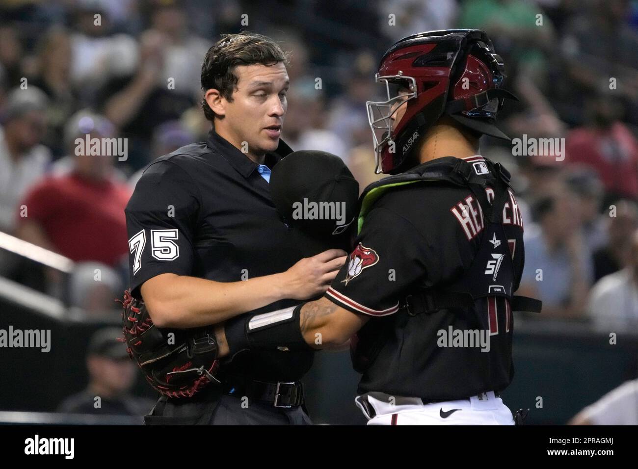 MLB umpire Edwin Jimenez is held up by Arizona Diamondbacks catcher Jose Herrera after he was ...