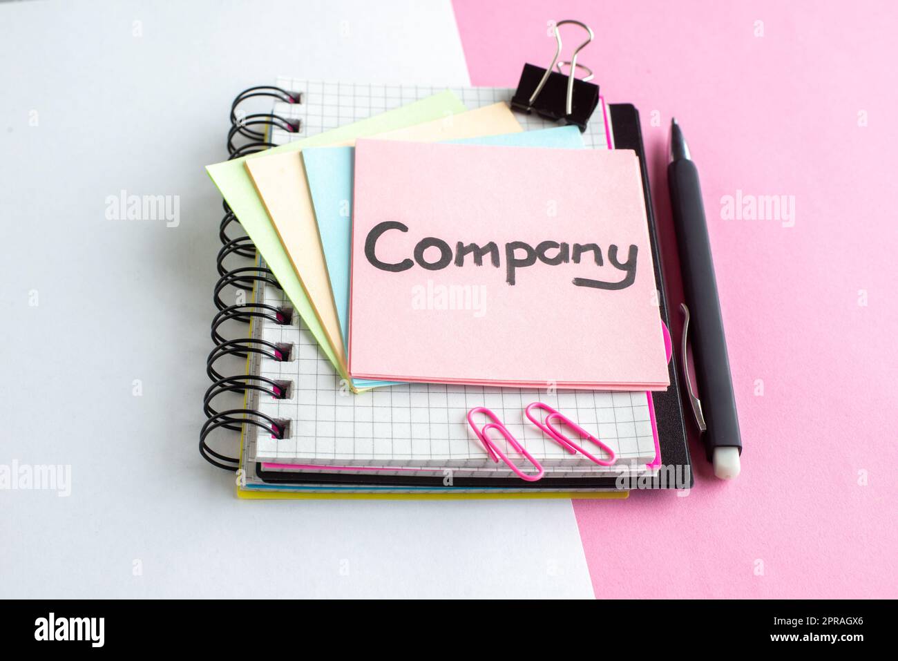 front view company written note with stickers on white-pink background ...
