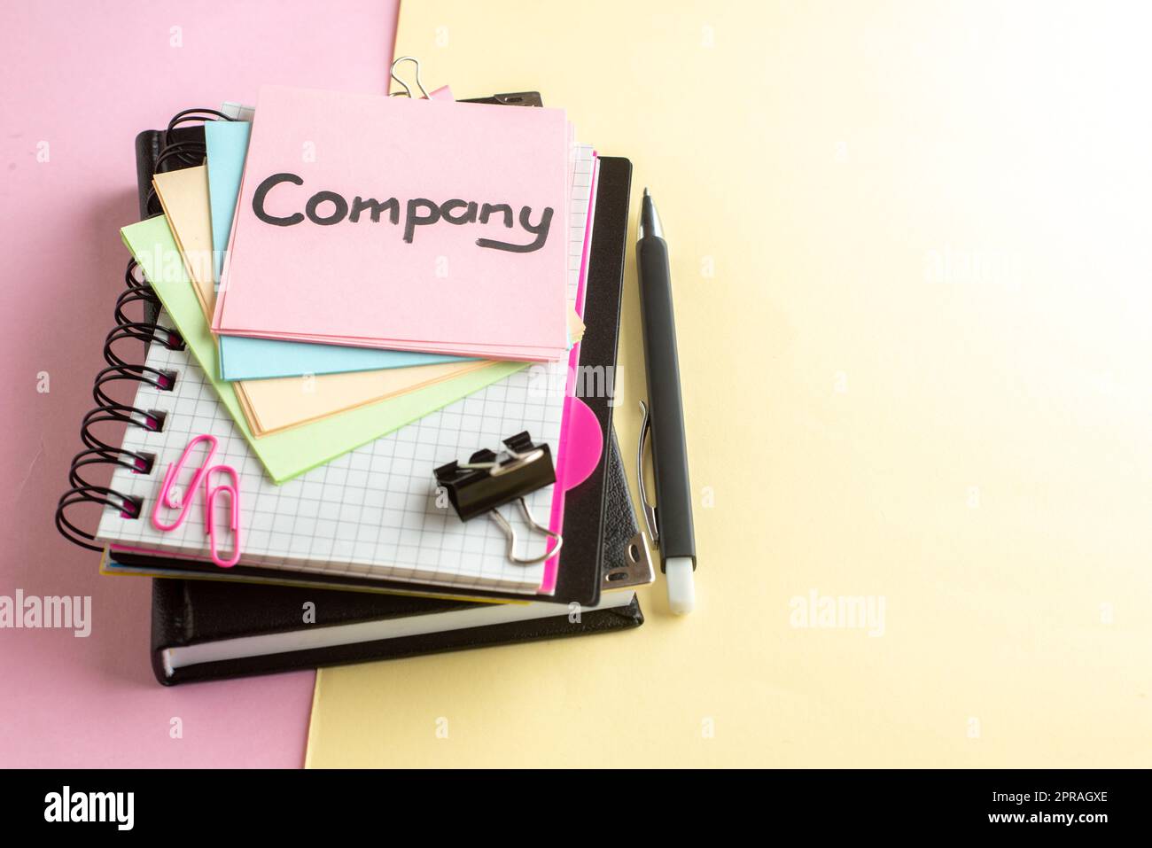 front view company written note with stickers on yellow-pink background ...