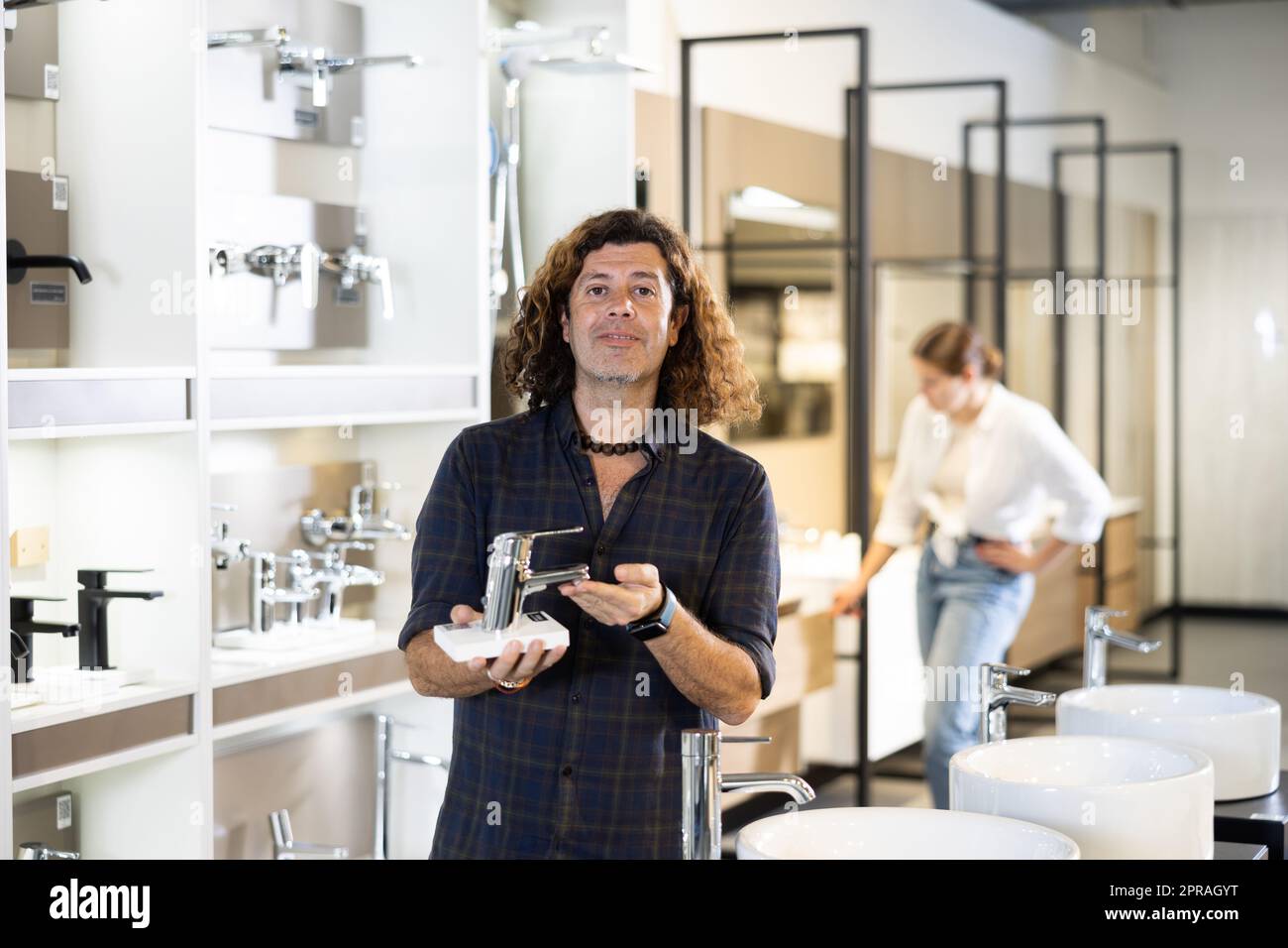 Confident male customer choosing bathroom faucet in store Stock Photo ...