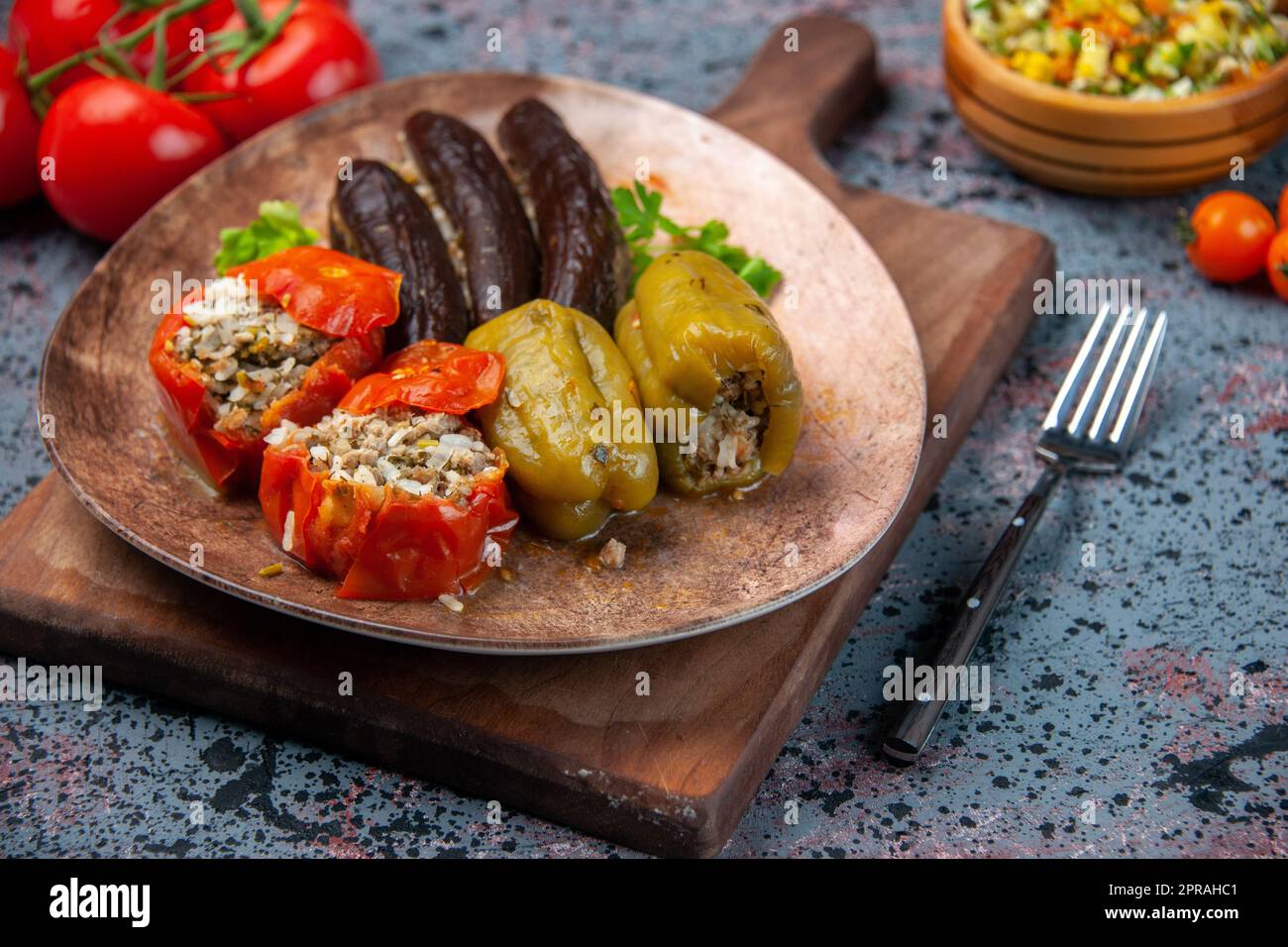 front view delicious vegetable dolma with salad and tomatoes on blue ...