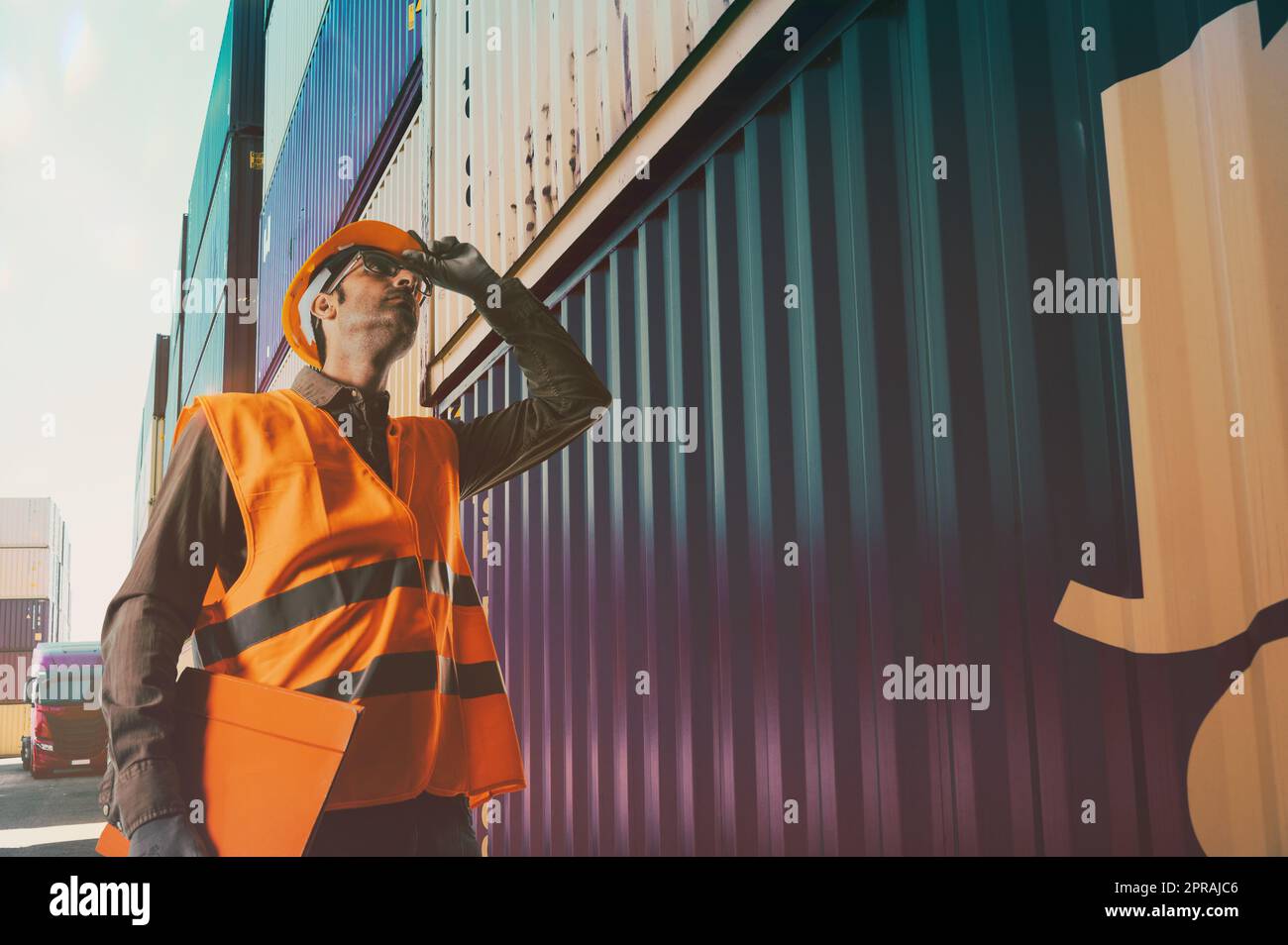 Man at work among containers in a commercial port Stock Photo - Alamy