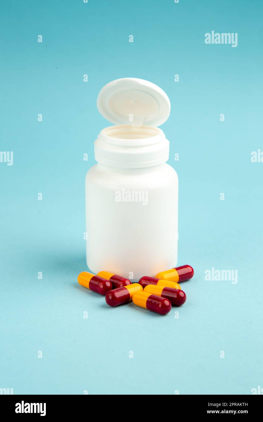 front view little pills can with pills on blue background color virus ...
