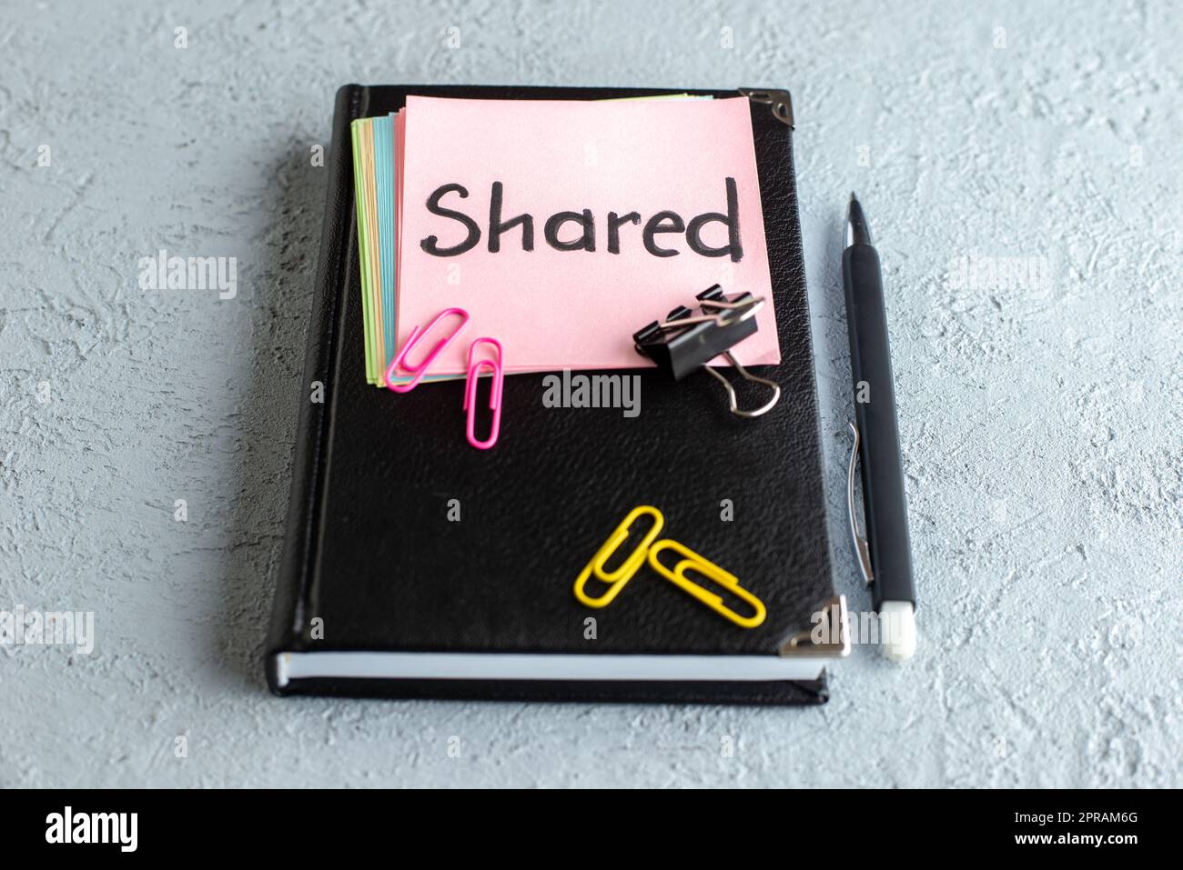 front view shared written note with stickers notepad and pen on white ...