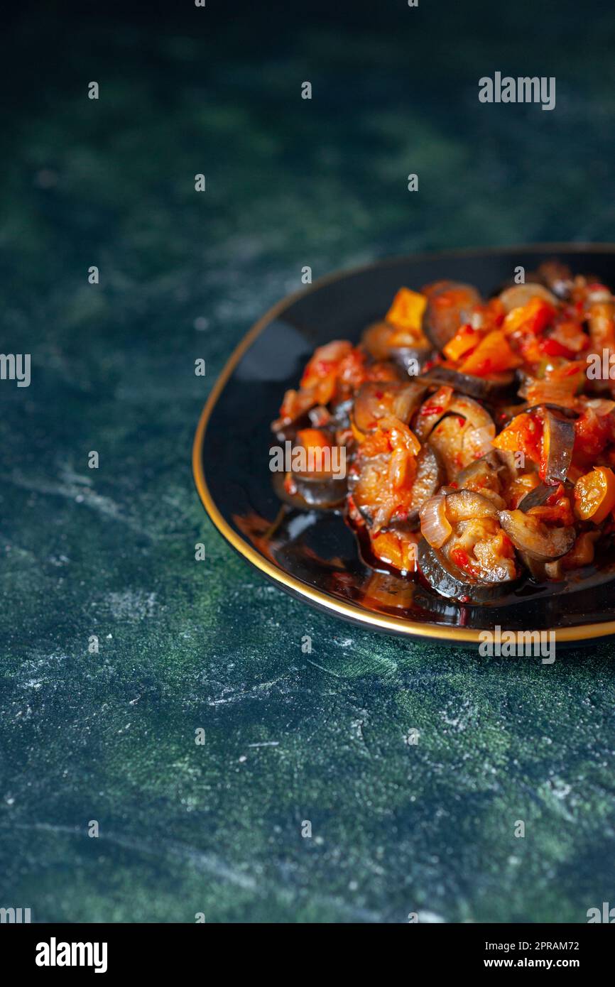 front view sliced cooked eggplants with extra dip inside plate on dark ...