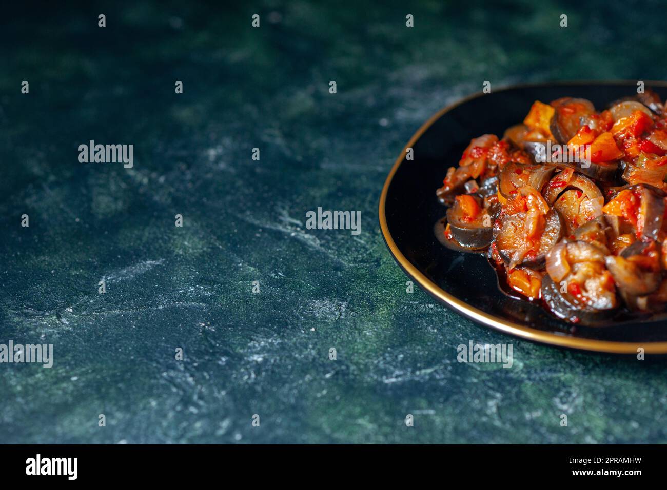 front view sliced cooked eggplants with extra dip inside plate on dark ...