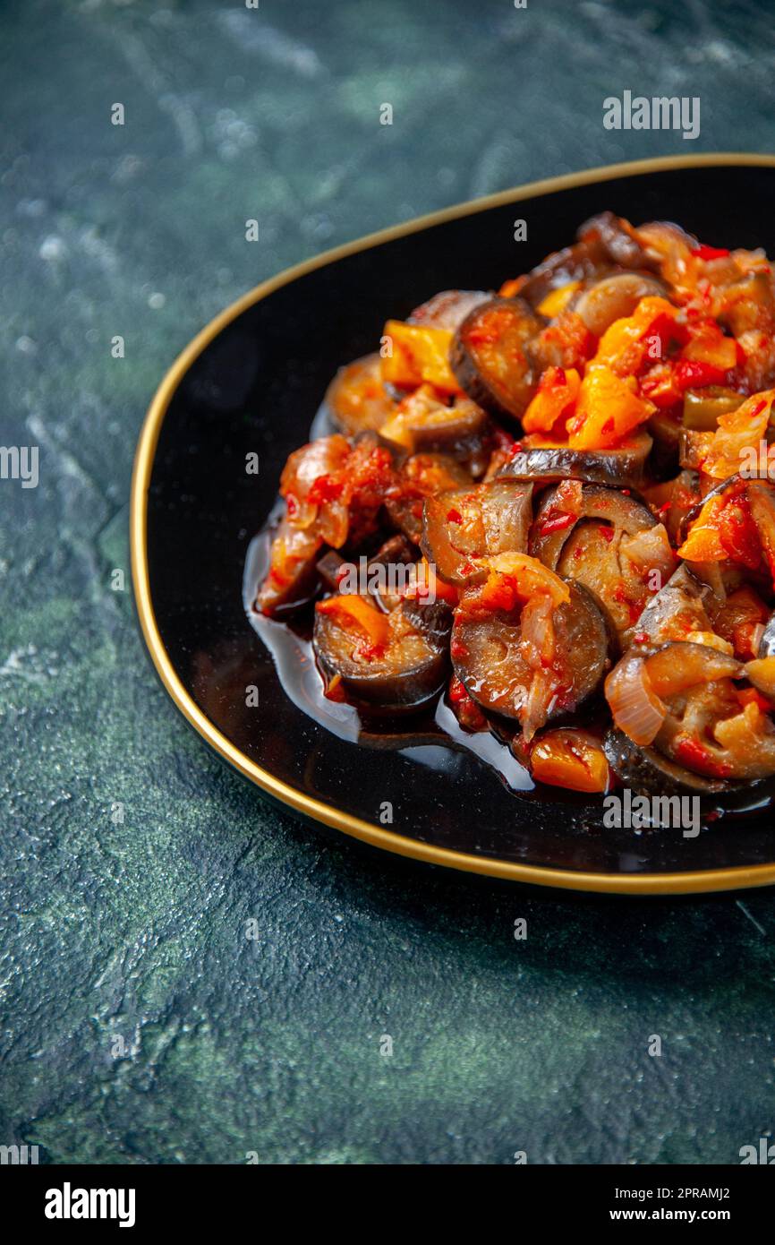 front view sliced cooked eggplants with extra dip inside plate on dark ...