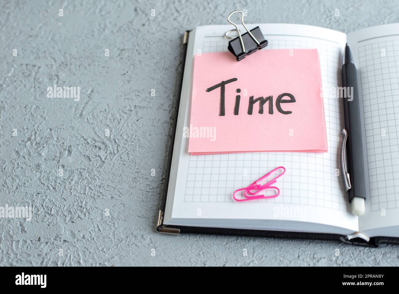 front view time written note with notepad and pen on white background ...