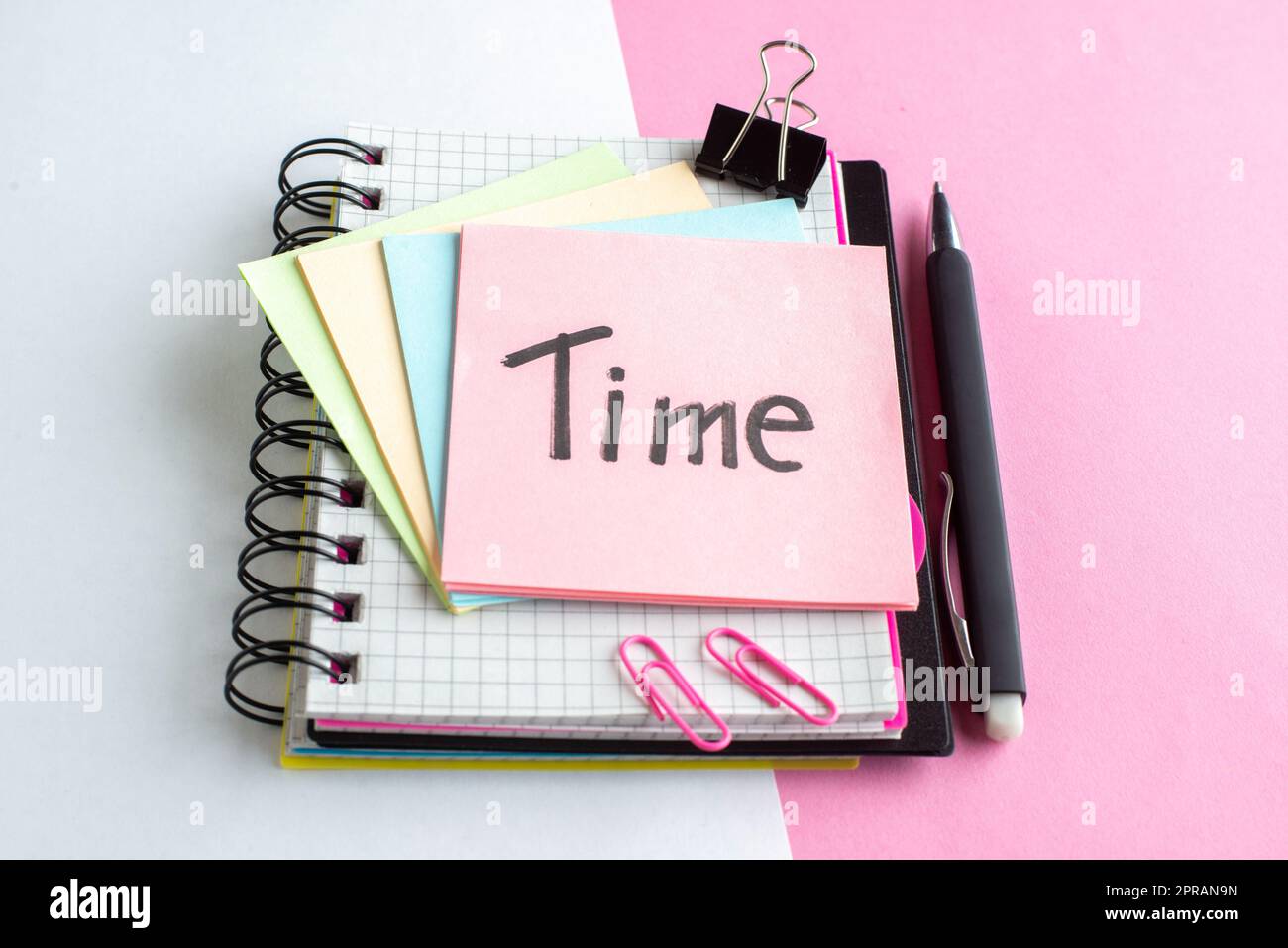 front view time written note with stickers on white-pink background ...