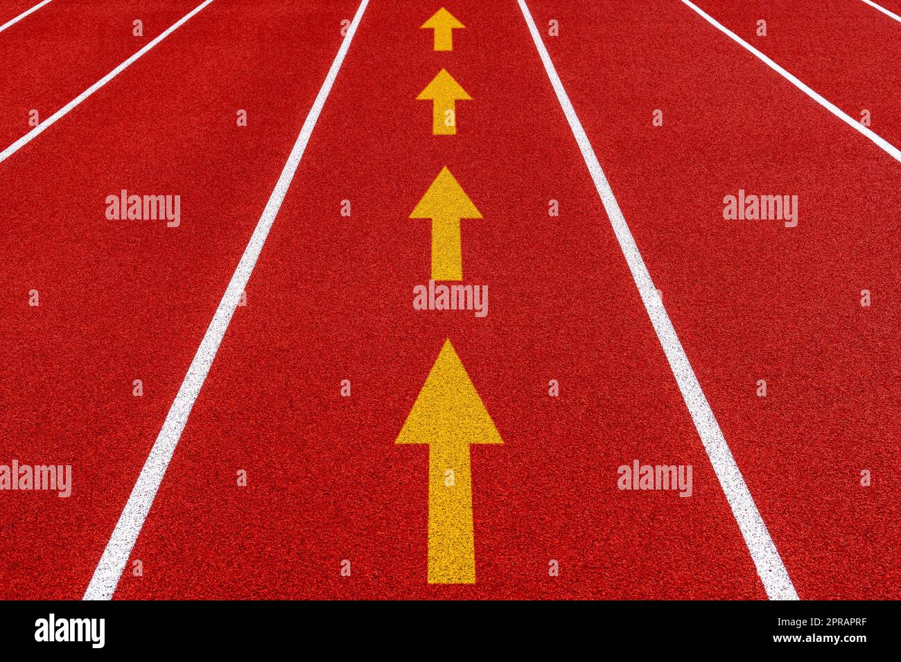 Outdoors stadium running red tartan track with white straight arrow ...