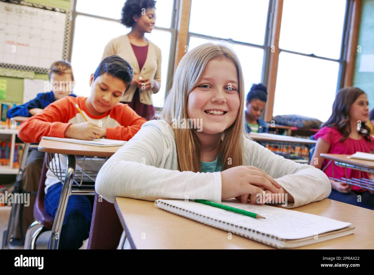 Shes a unique member of her class. a young girl sitting in class with ...