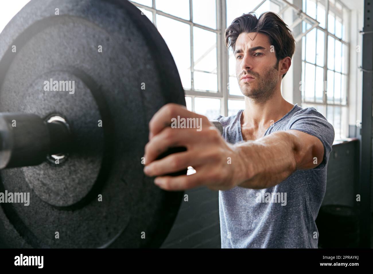 Getting ready to lift. a young man about to work out with weights in ...