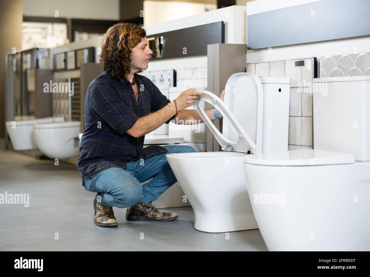 Confident male customer choosing new toilet in hardware store Stock ...