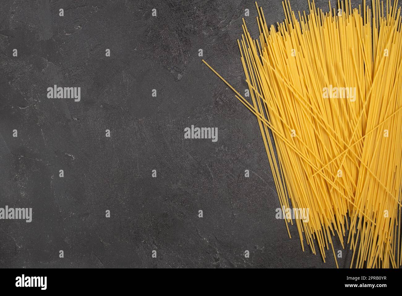 top view raw italian pasta yellow colored and long on the dark ...