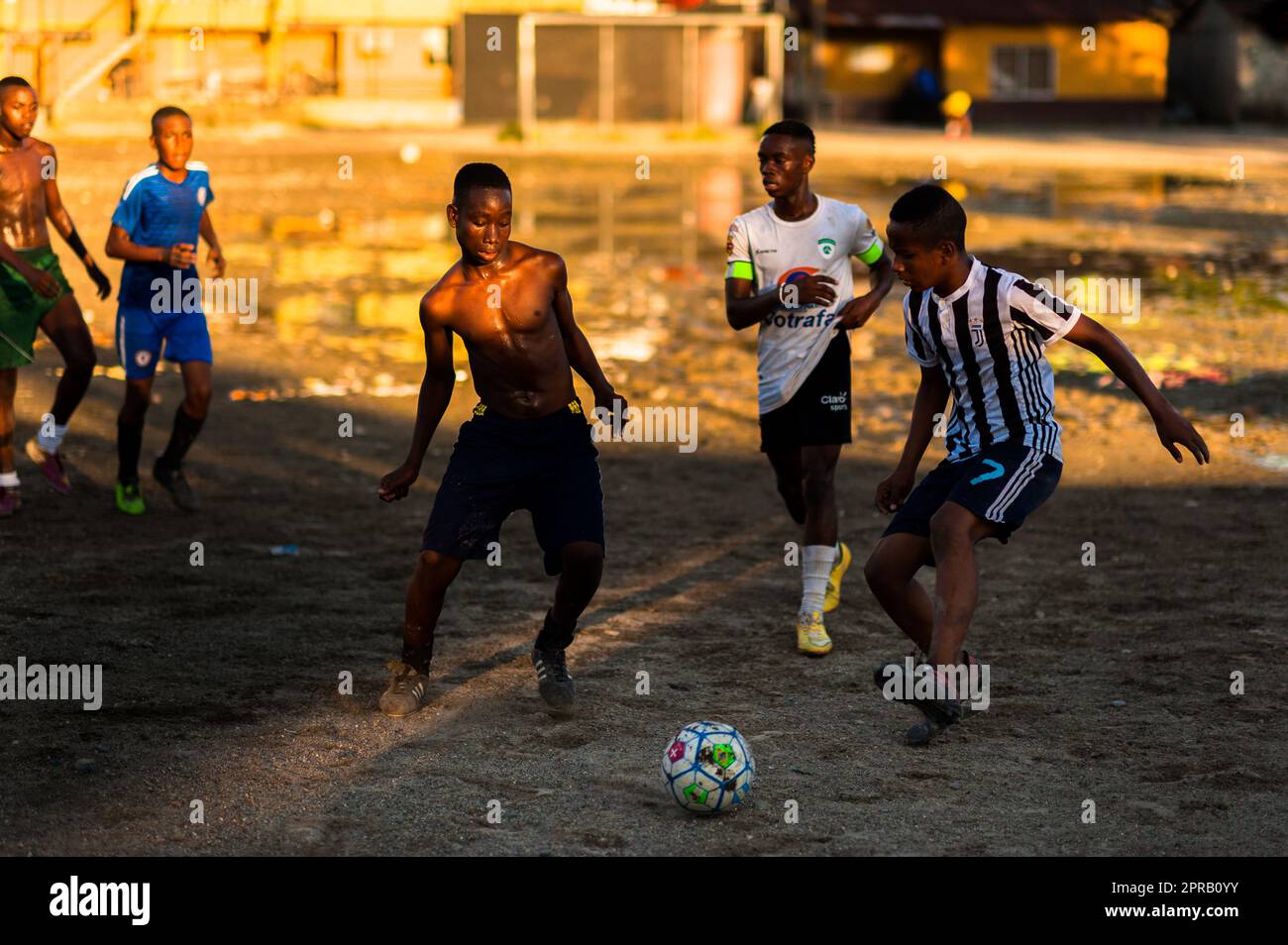 Young Afro-Colombian football players compete for the ball during a ...
