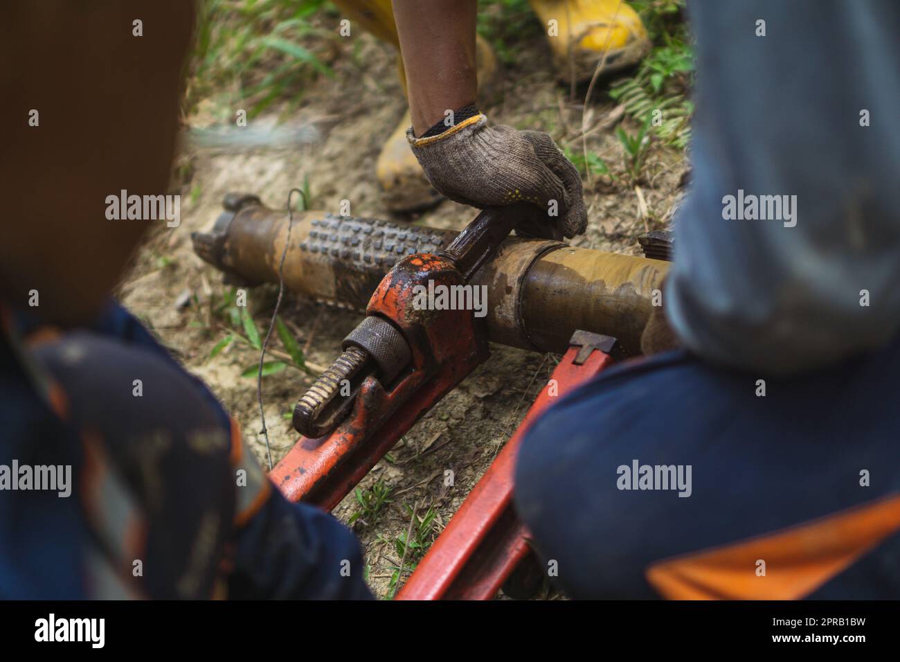 team of labour worker, open PCD drill bit using wrench or spanner, in ...