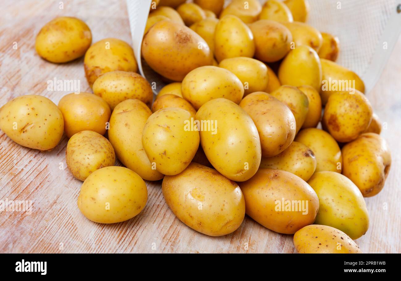 Pile of clean young potato tubers poured out of basket Stock Photo - Alamy