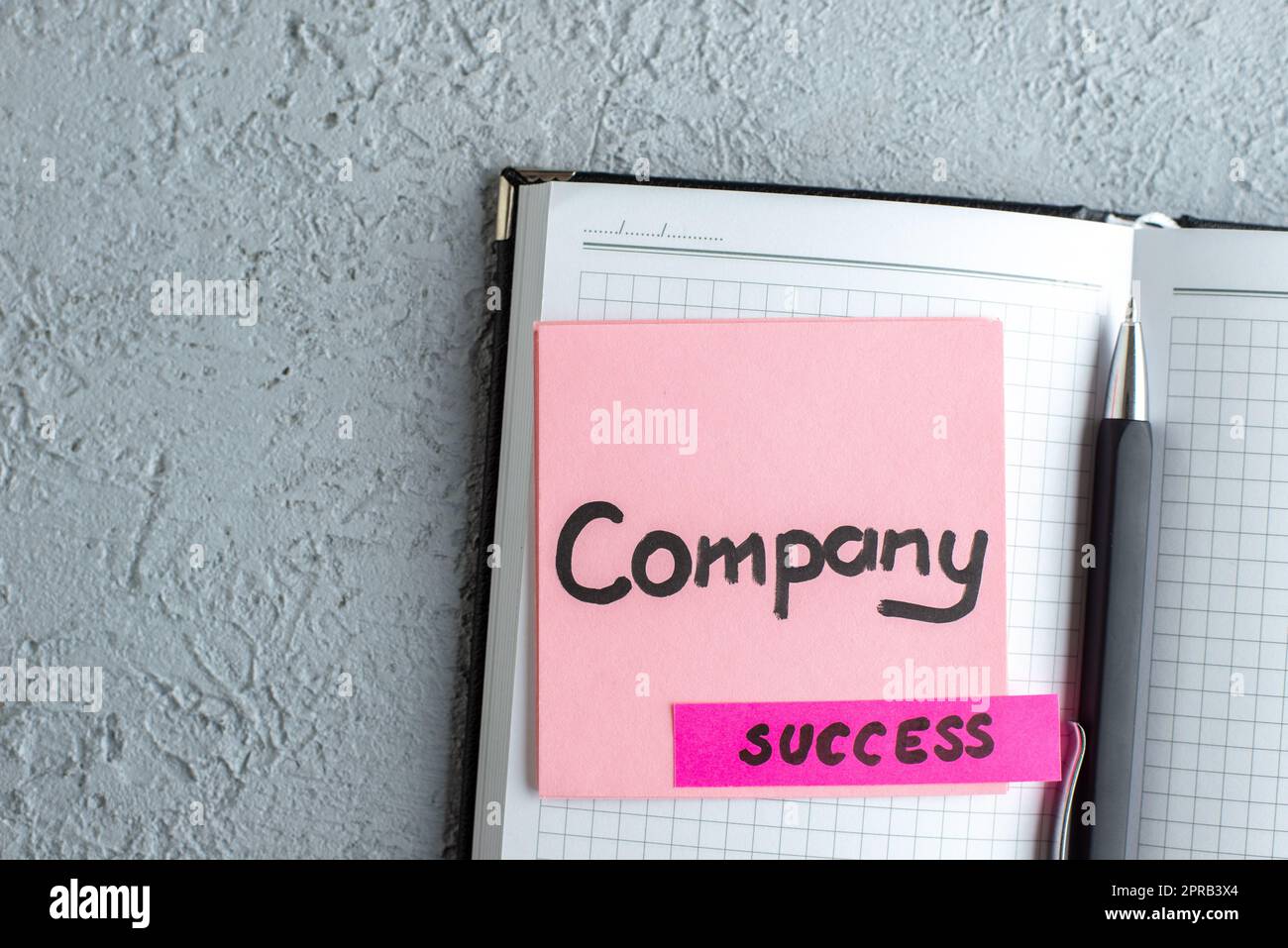 top view company written note with notepad and pen on white background ...