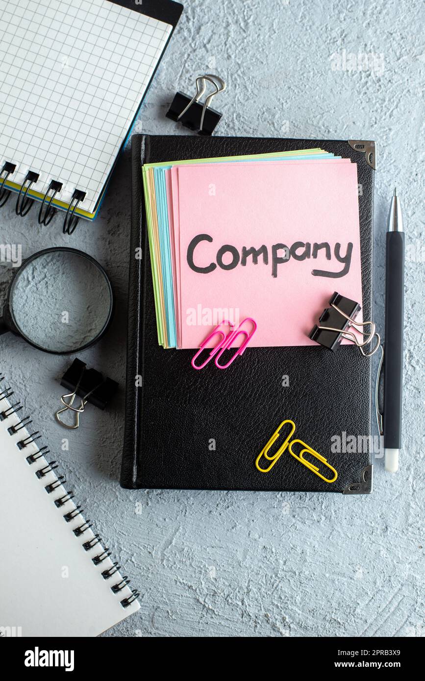 top view company written note with stickers notepad and pen on white ...