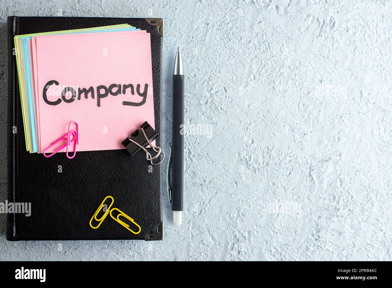 top view company written note with stickers notepad and pen on white ...