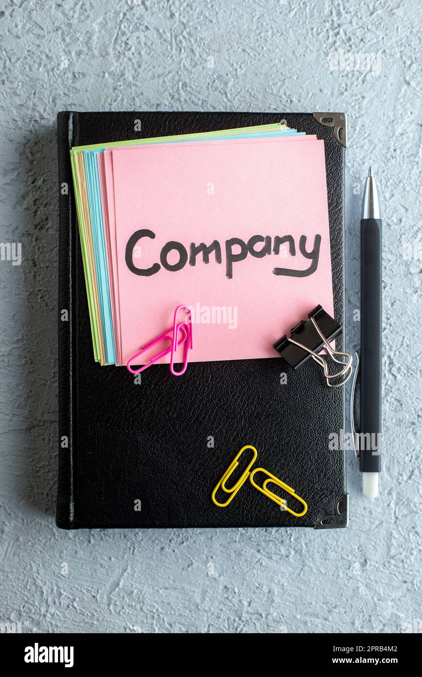 top view company written note with stickers notepad and pen on white ...