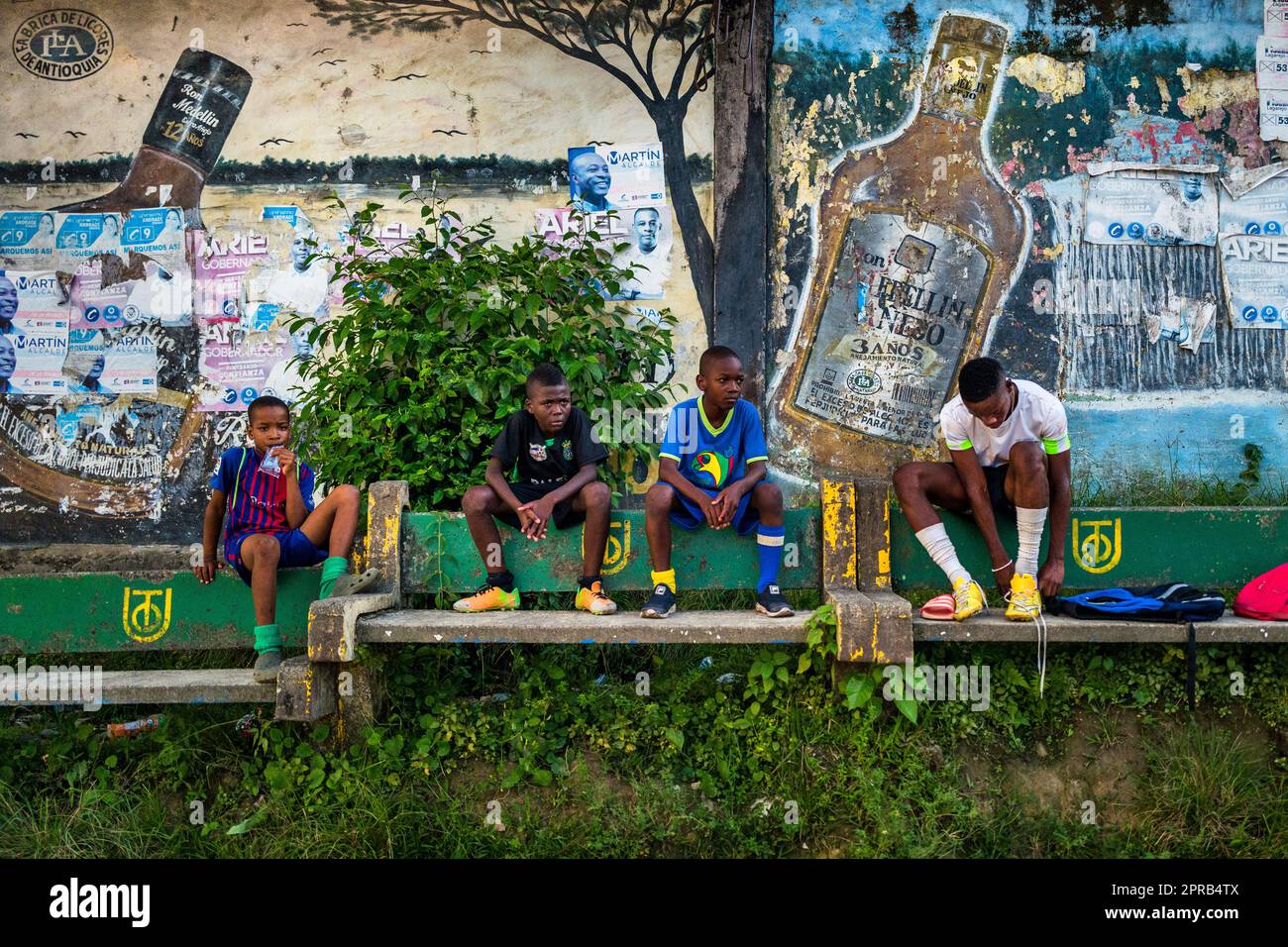 Young Afro-Colombian football players wait on the bench for the start ...