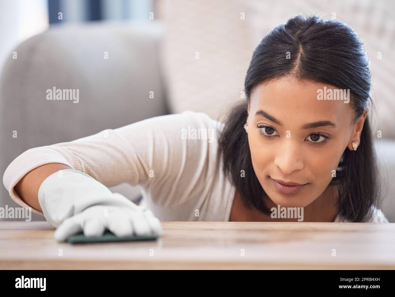 Squeaky clean surfaces. a young woman cleaning a surface at home Stock ...