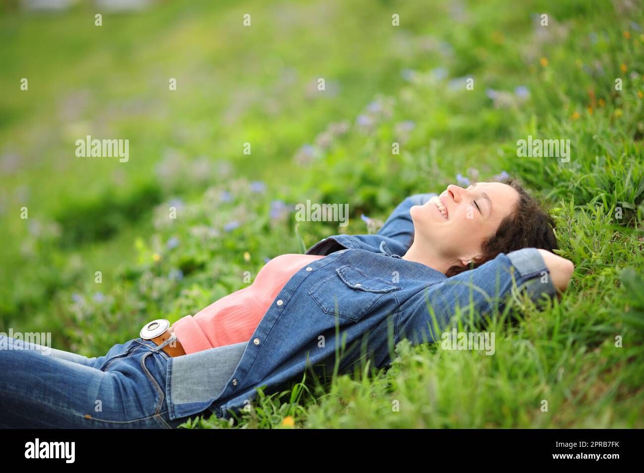 Woman lying on the grass in a park relaxing Stock Photo - Alamy