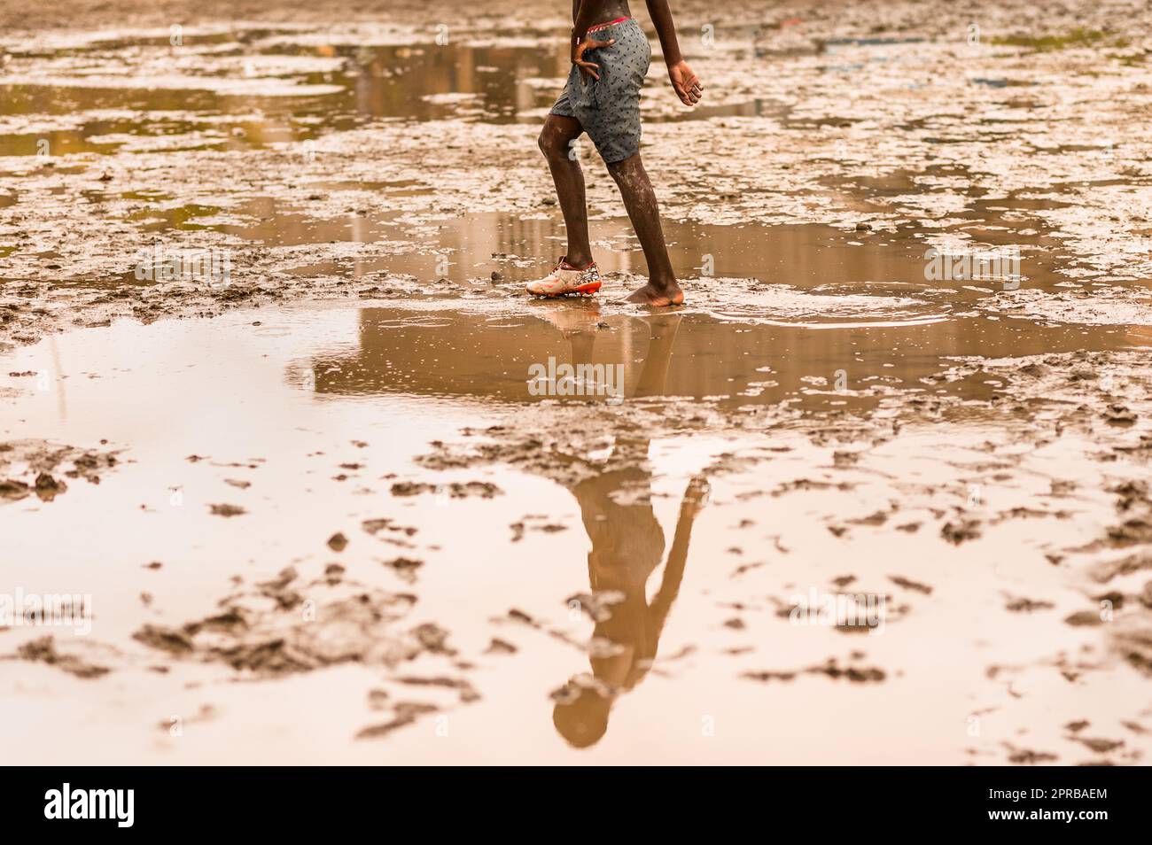 A young Afro-Colombian footballer, wearing only one football boot ...