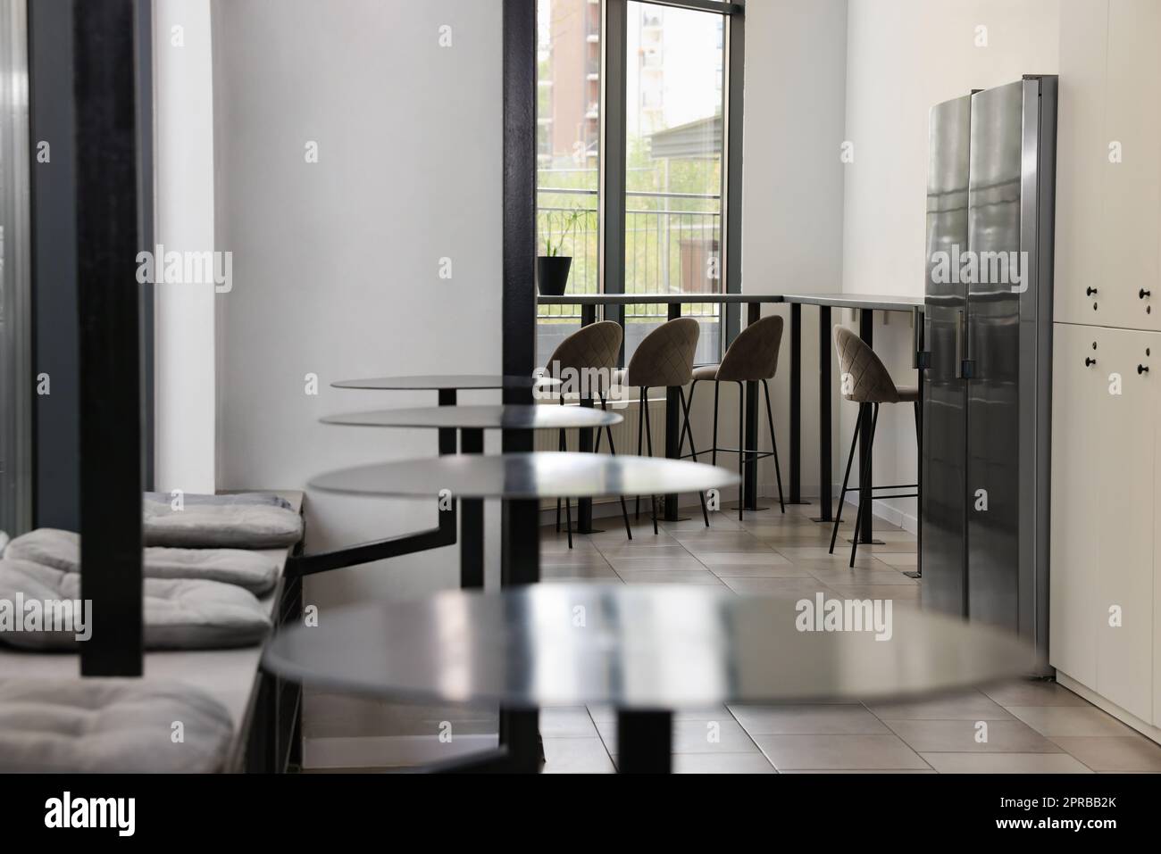Hostel dining room interior with modern furniture and refrigerators ...