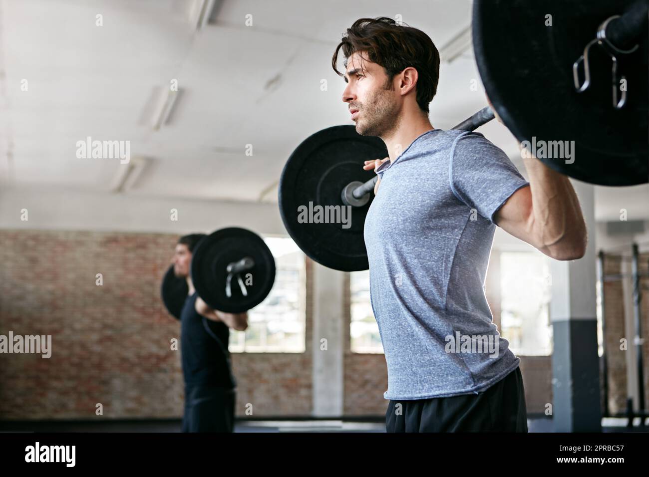Push harder, get stronger. young men working out with weights in the ...
