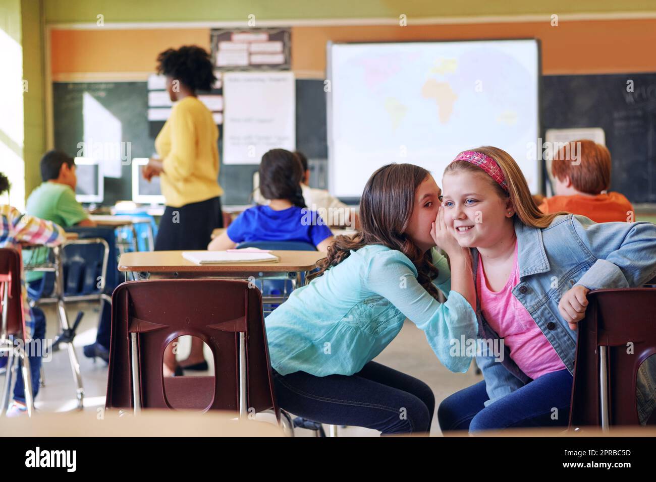 Child whispering classroom hi-res stock photography and images - Alamy