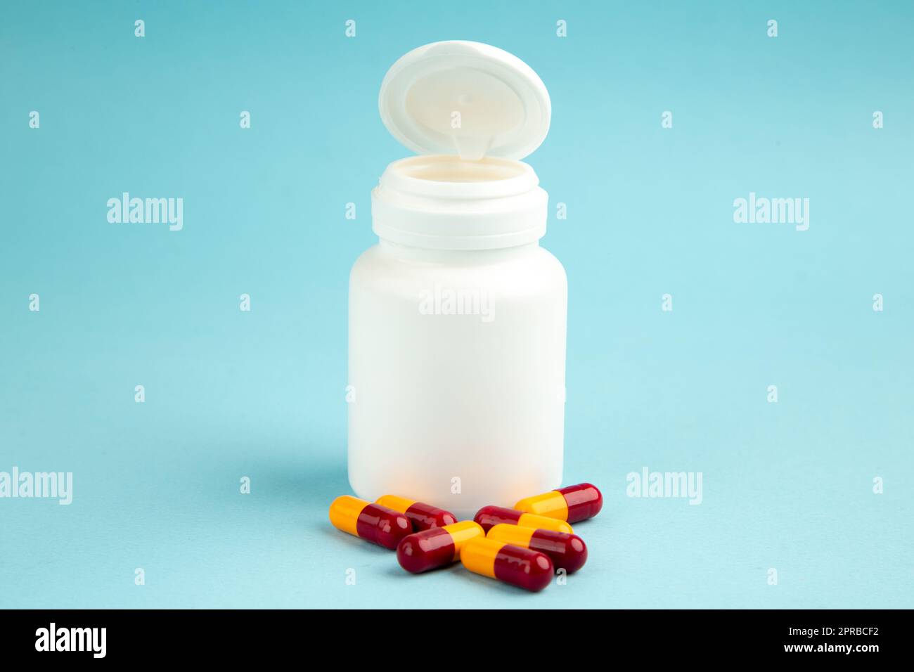 front view little pills can with pills on blue background color virus ...
