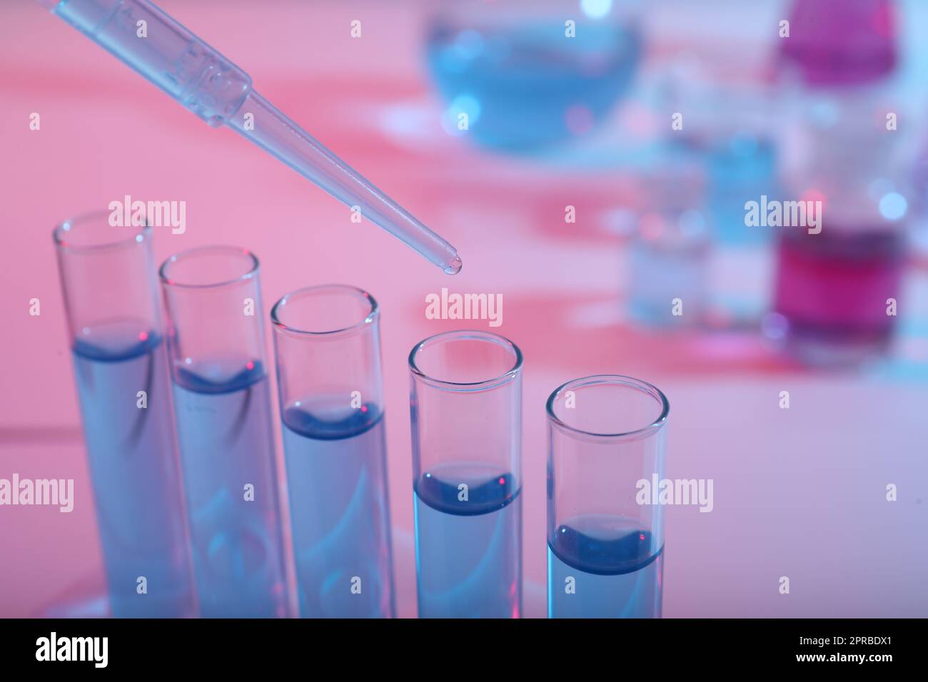 Dripping reagent into test tube with blue liquid, closeup. Laboratory ...