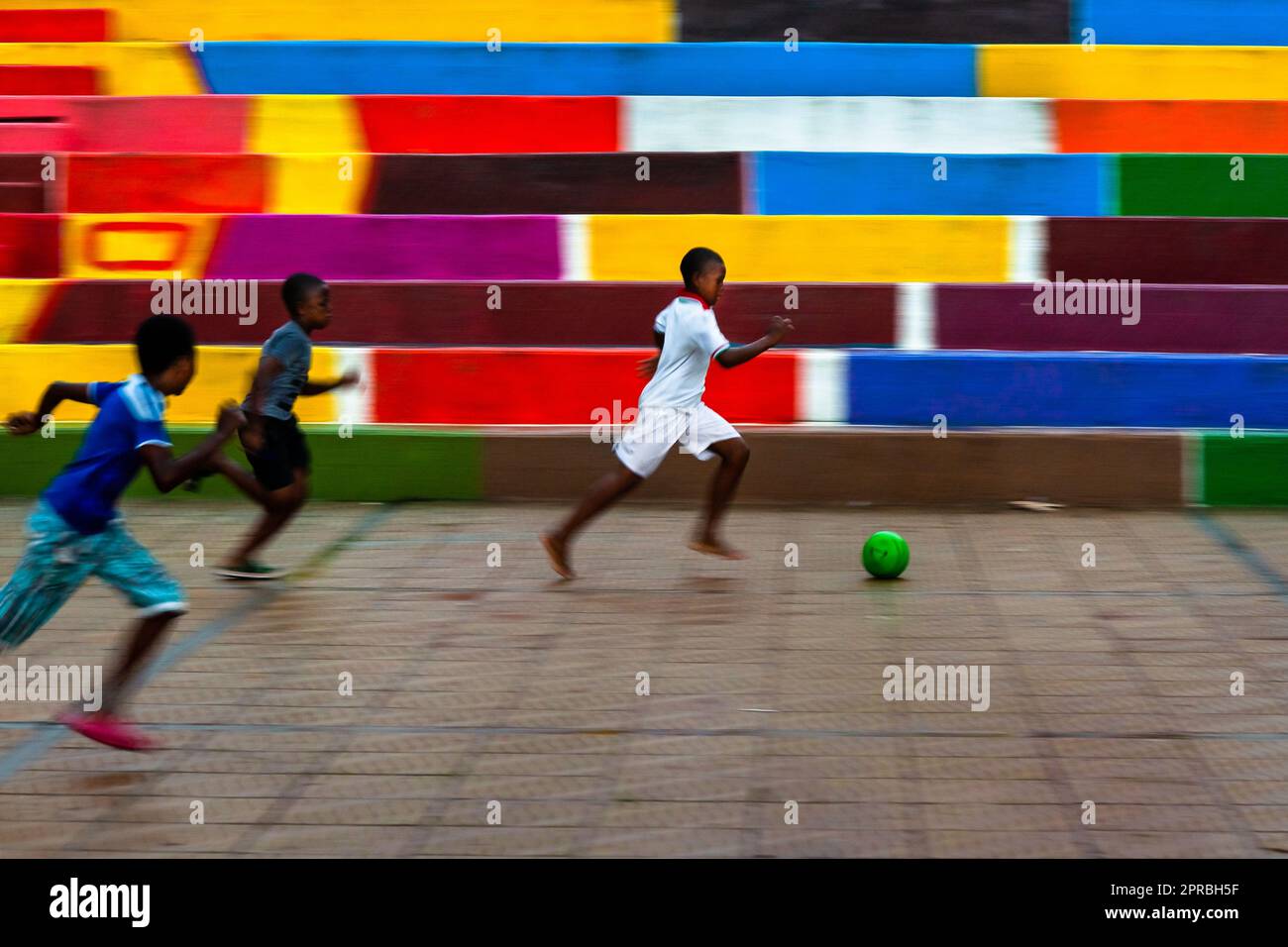 Afro-Colombian boys play street football on the river waterfront in ...