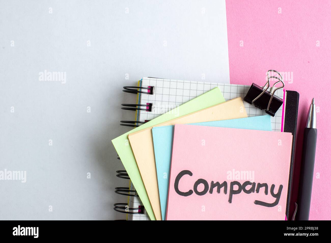 top view company written note on pink sticker white-pink background job ...