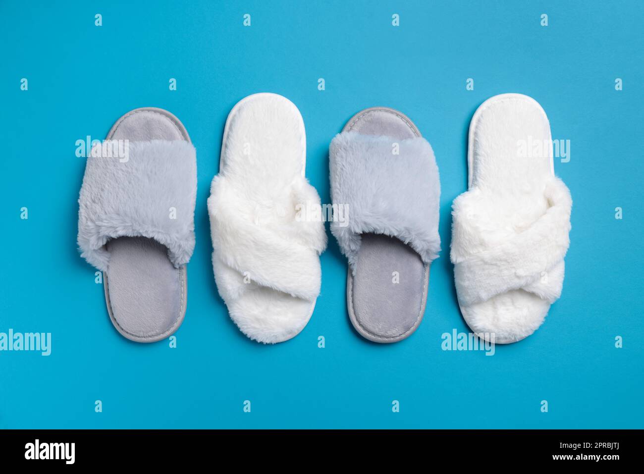 Different soft fluffy slippers on light blue background, flat lay Stock ...