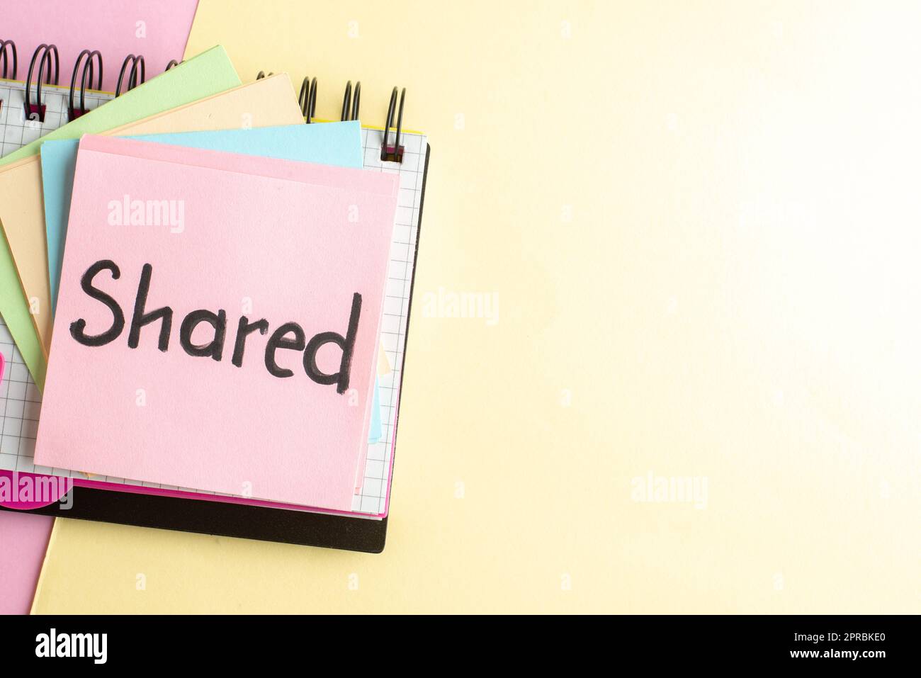 top view shared written note with stickers on yellow-pink background ...