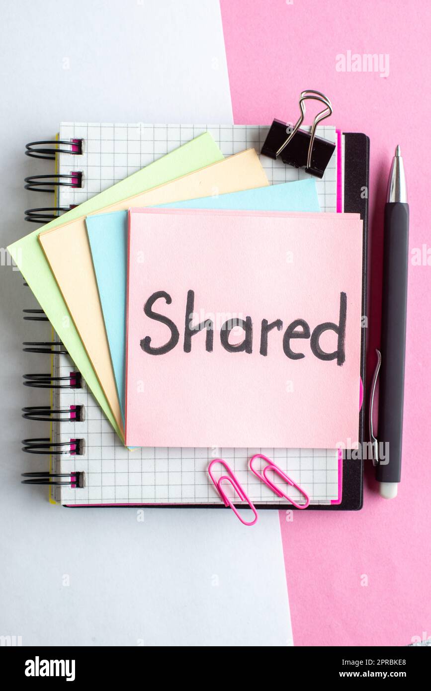 top view shared written note with stickers on white-pink background ...