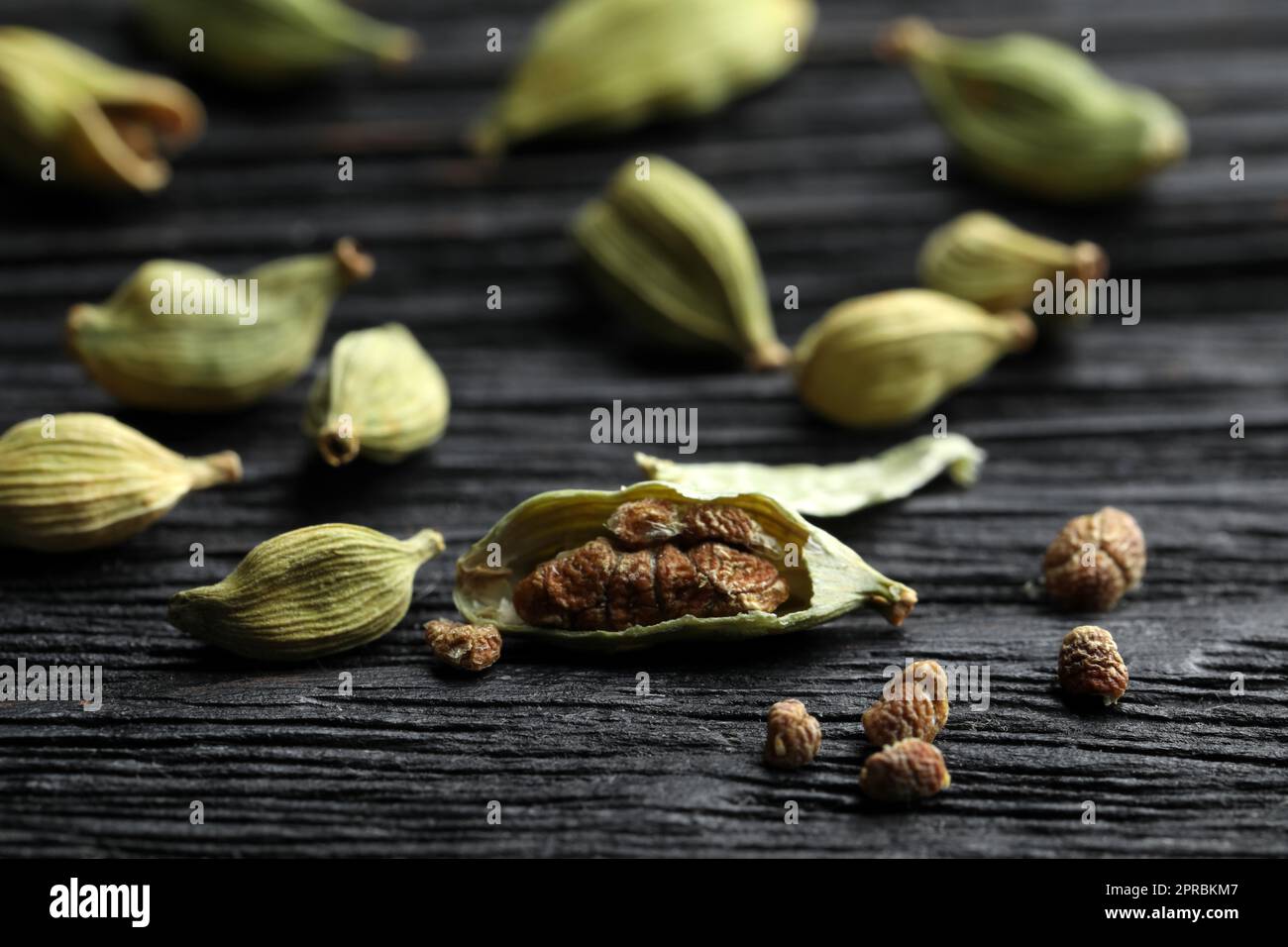Dry cardamom pods on black wooden table, closeup Stock Photo - Alamy