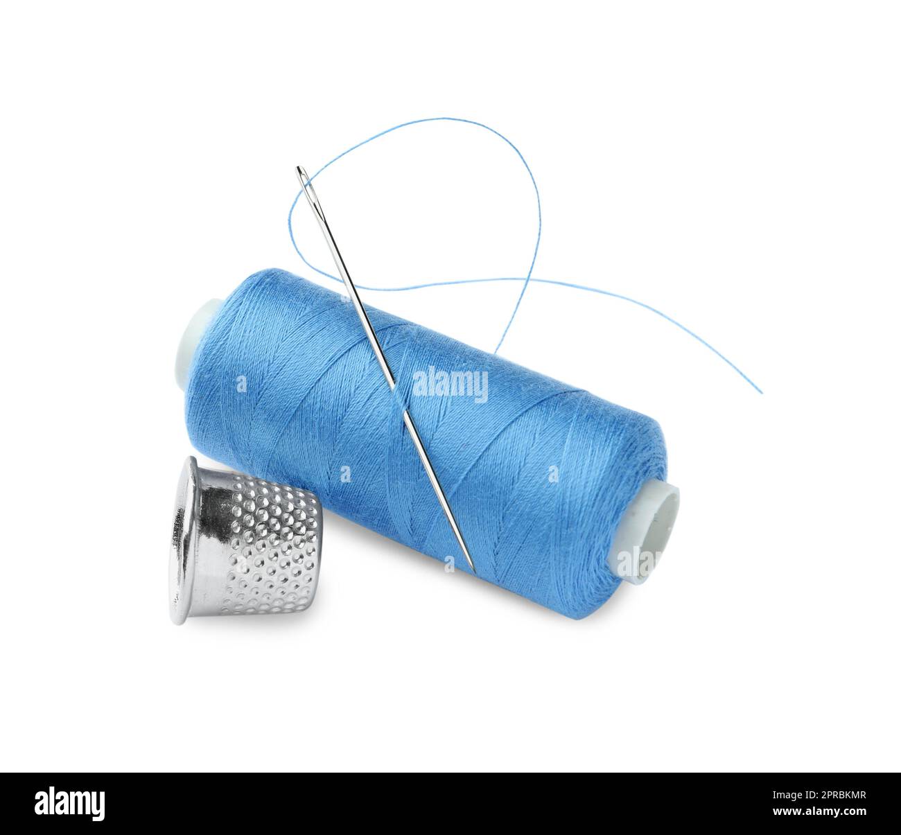 Spool of light blue sewing thread with needle and thimble on white ...