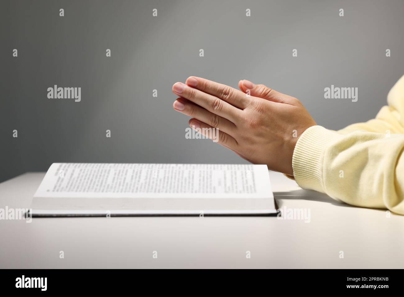 Adult woman praying over grey hi-res stock photography and images - Alamy