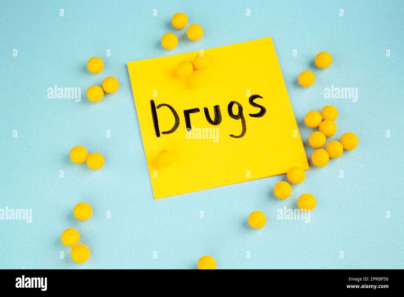 top view yellow pills with drugs written note on blue background lab ...